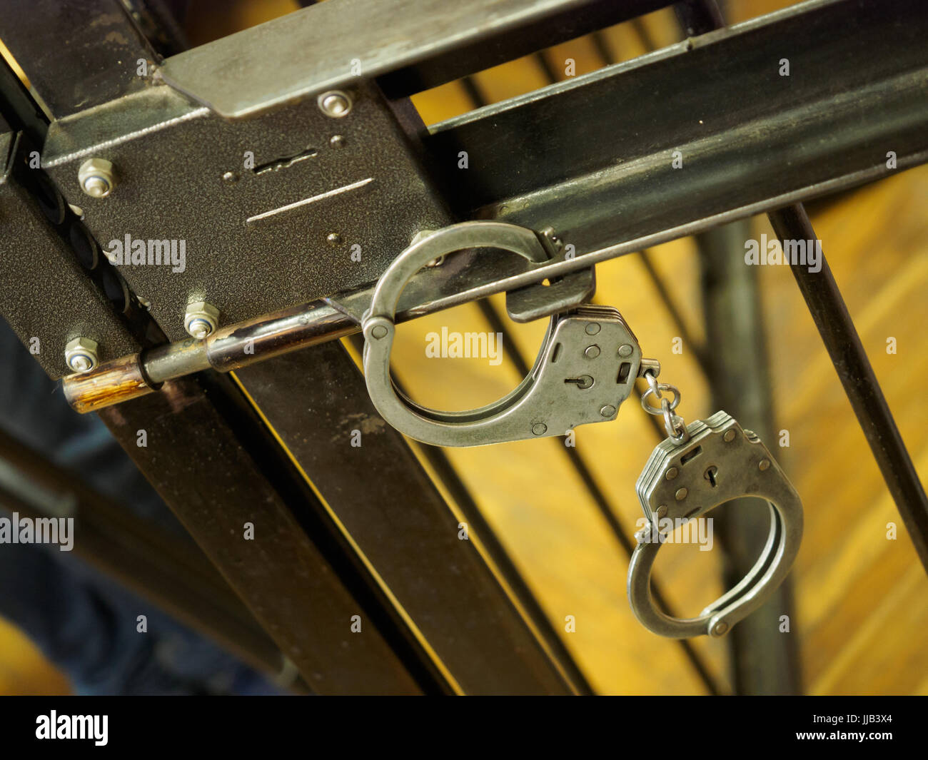 Handcuffs and lattice cells for prisoners Stock Photo - Alamy