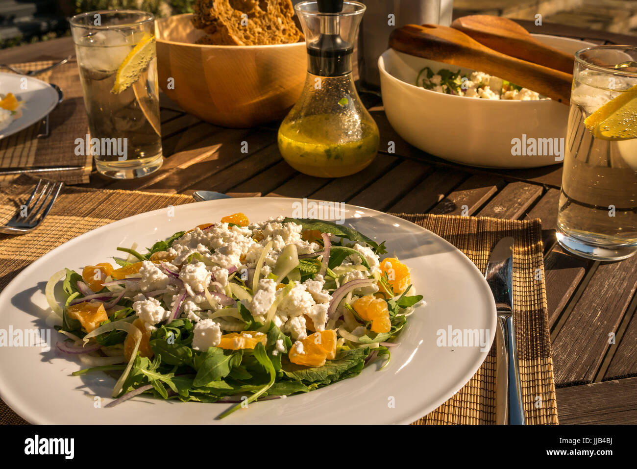 Close up of Summer salad served outside on garden deck table in sun ...
