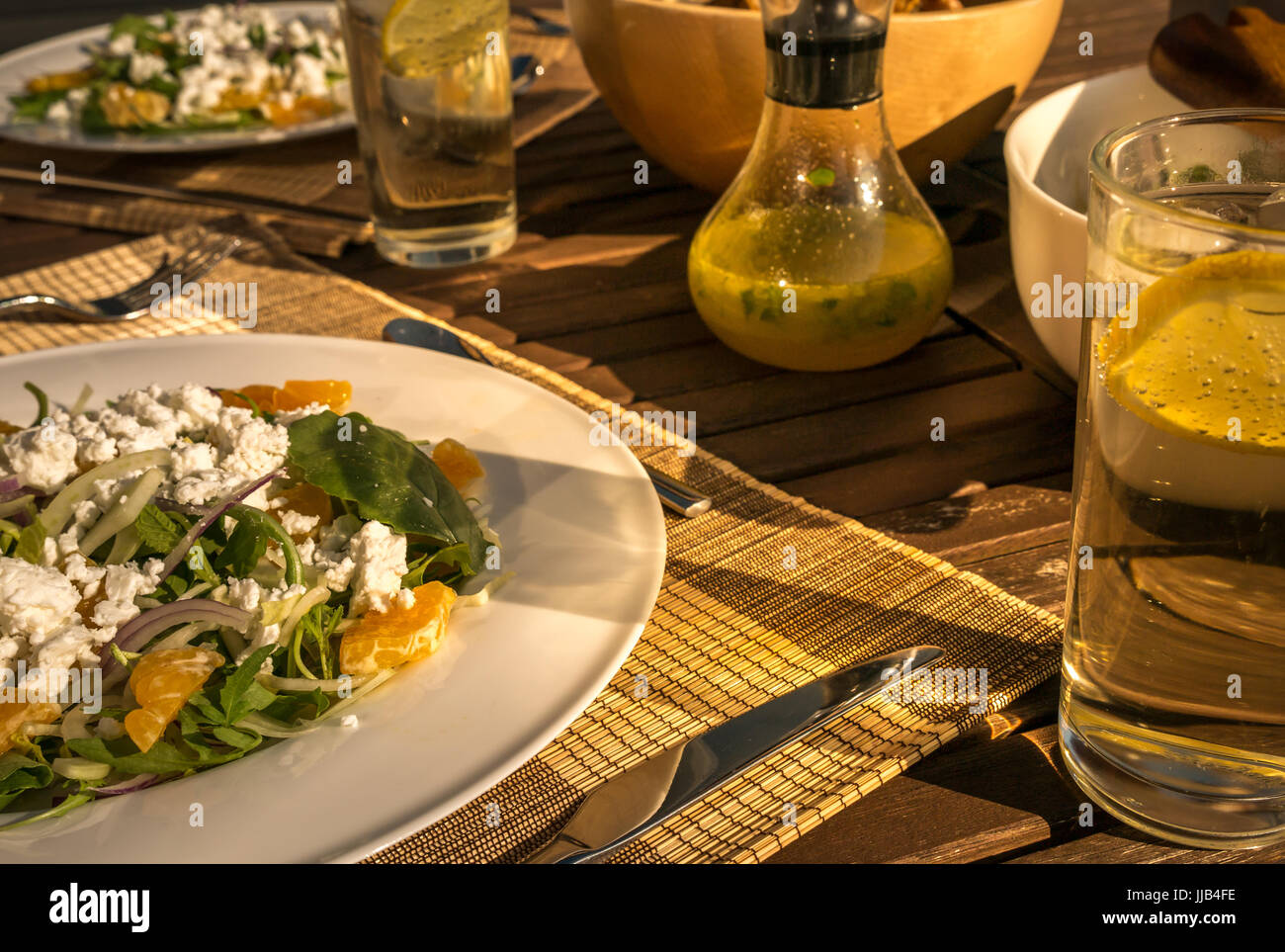 Close up of Summer salad served outside on garden deck table in sun ...