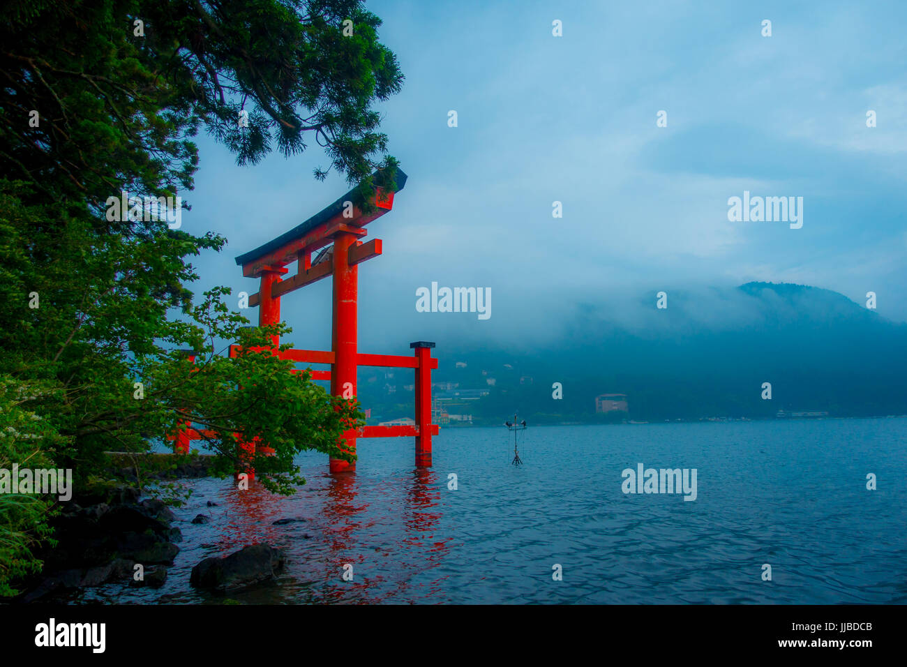 Bright red Torii gate submerged in the waters of Ashi lake, caldera ...