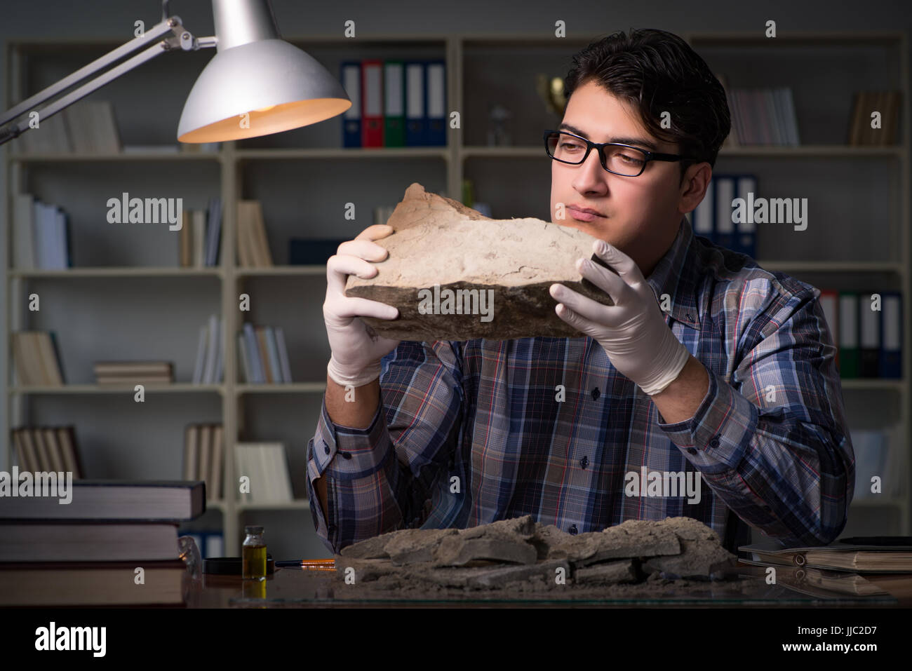 Archeologist working late night in office Stock Photo - Alamy