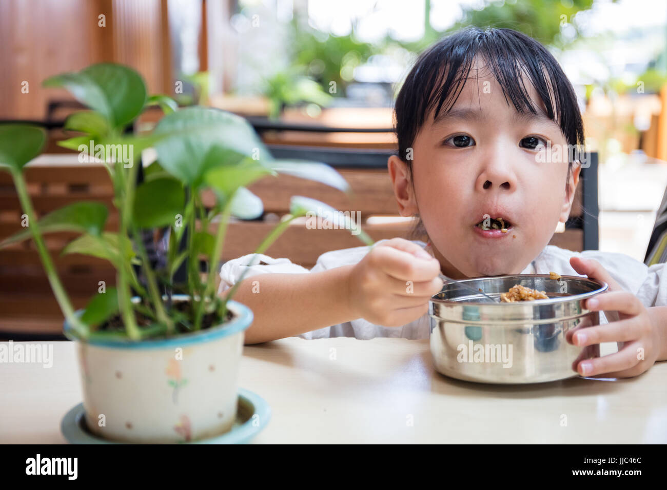 Asian Chinese little girl eating fried rice at outdoor cafe Stock Photo ...