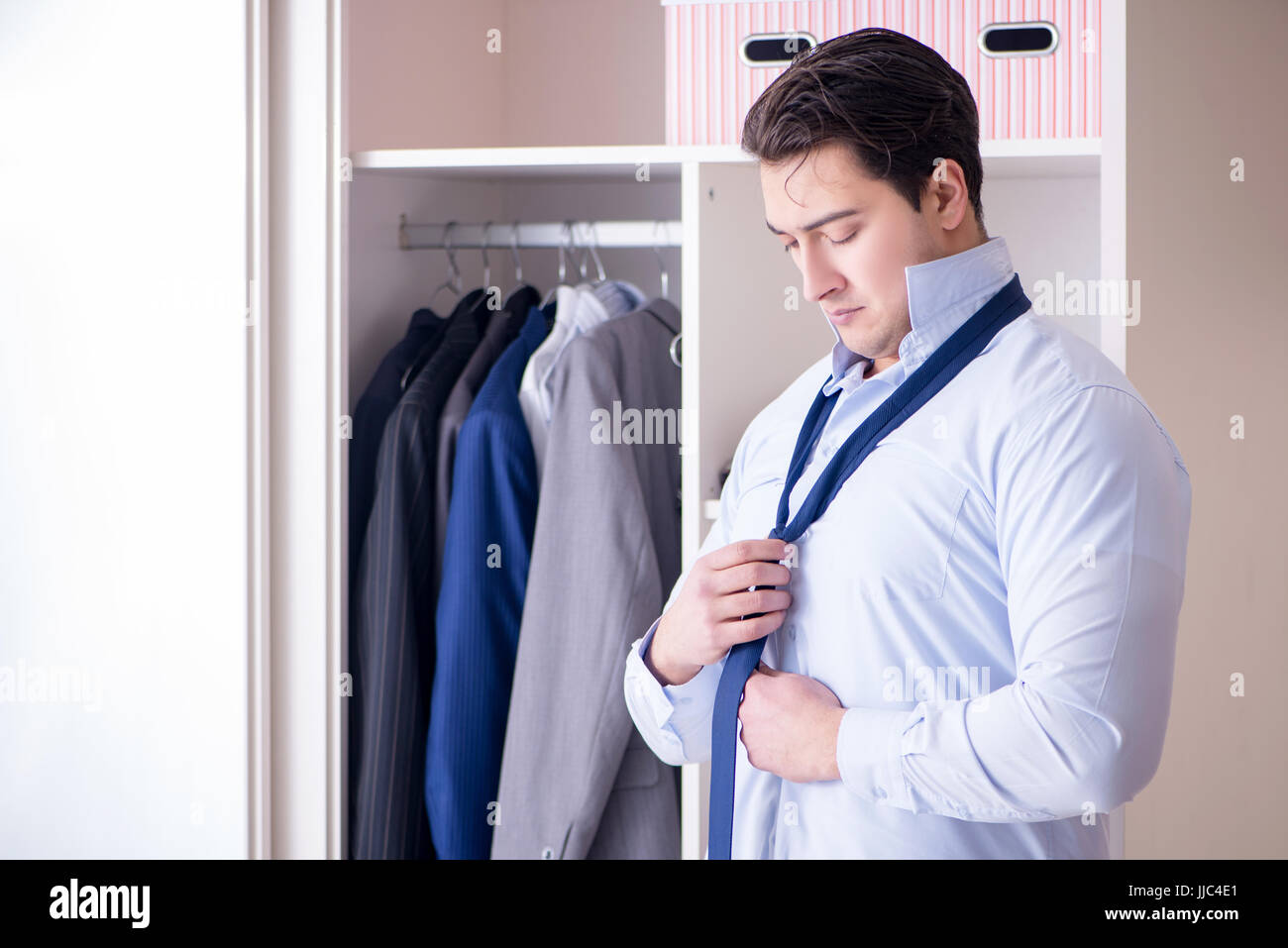 Young man businessman getting dressed for work Stock Photo - Alamy