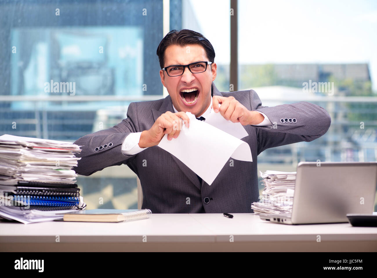 Angry businessman with too much work in office Stock Photo - Alamy