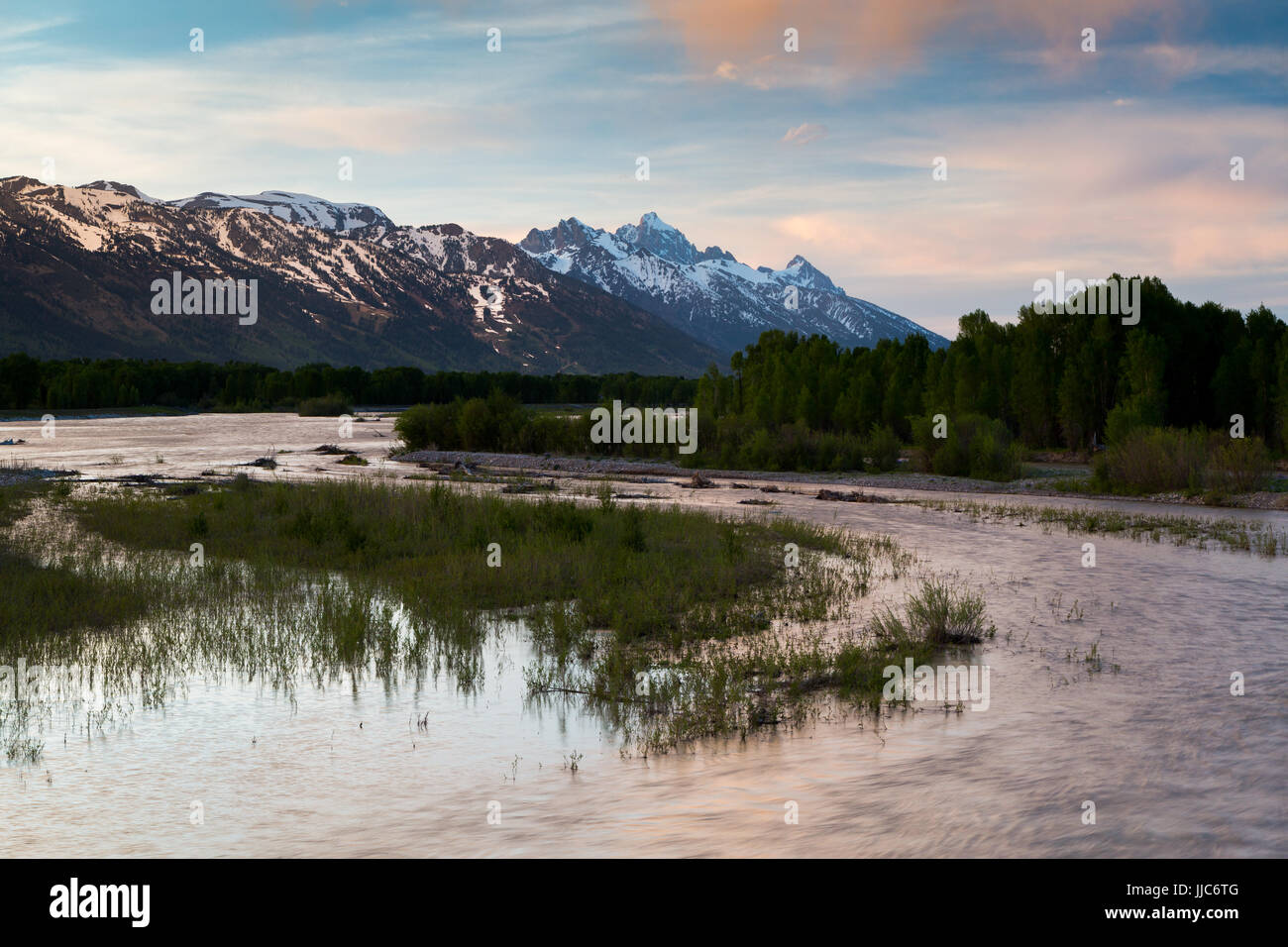 The Snake River reflecting a colorful sunset above the Teton Mountains ...