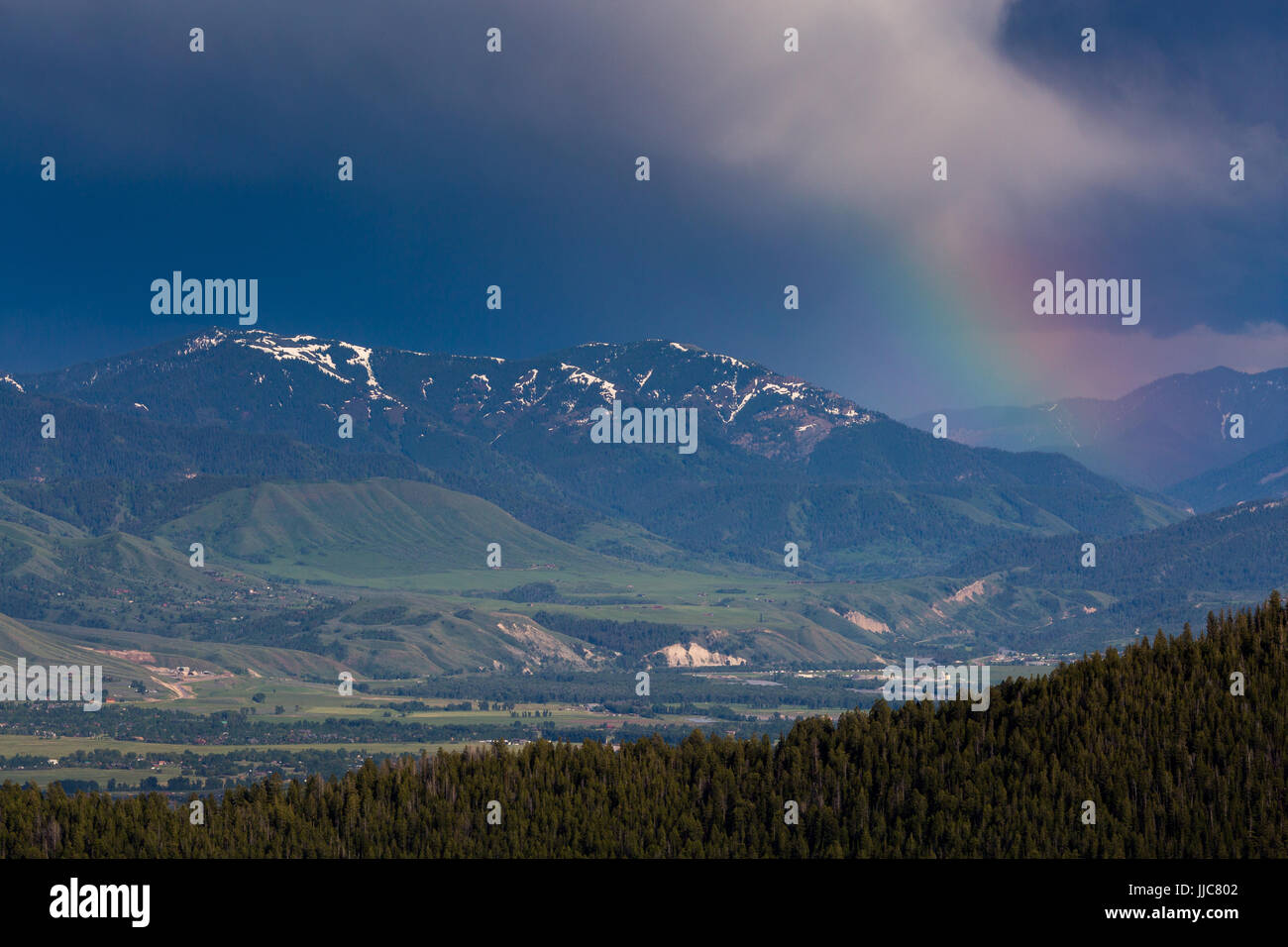 A rainbow arching into storm clouds above the southern end of Jackson Hole between the Gros ...