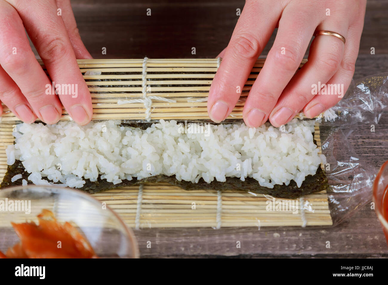 Man's hands hold bamboo mat. Bamboo mat and cooking board. Chef makes ...
