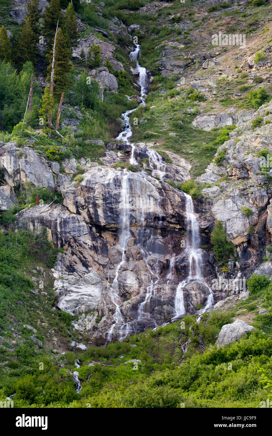 A snow melt waterfall pouring over rocky cliffs near Death Canyon. Grand Teton National Park ...