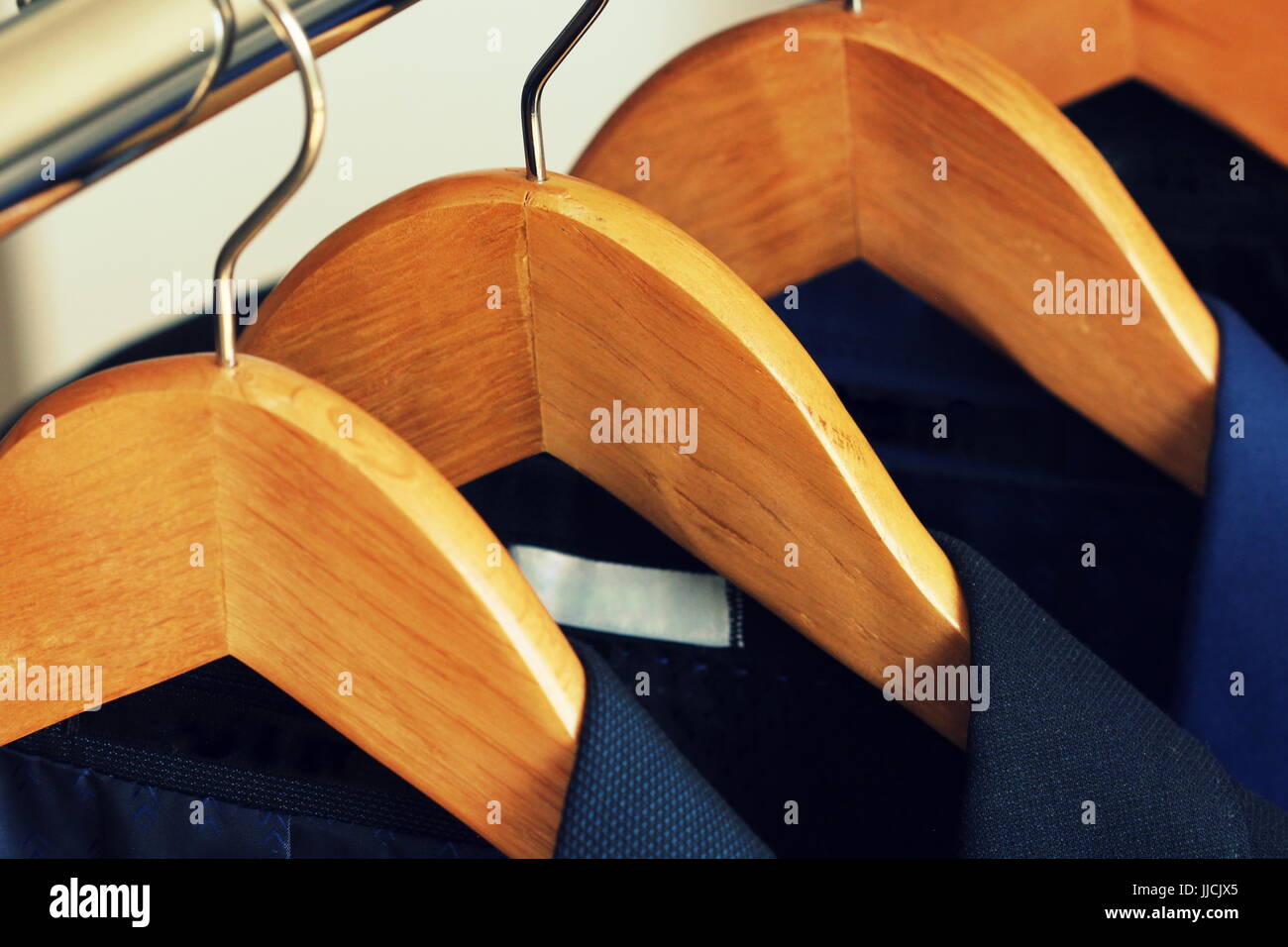 Row of men's suits hanging in closet Stock Photo - Alamy