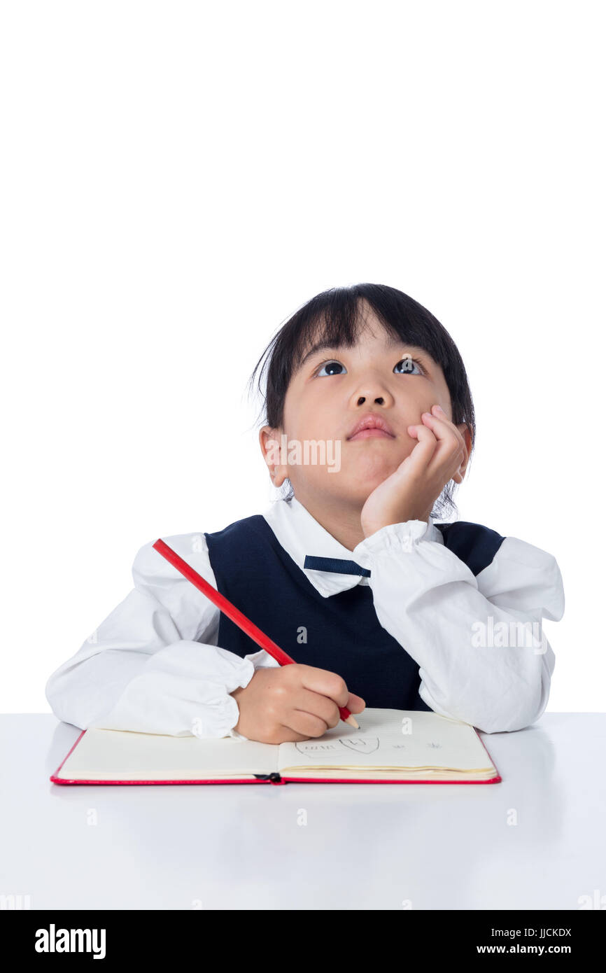 Asian Little Chinese girl writing homework in isolated white background ...