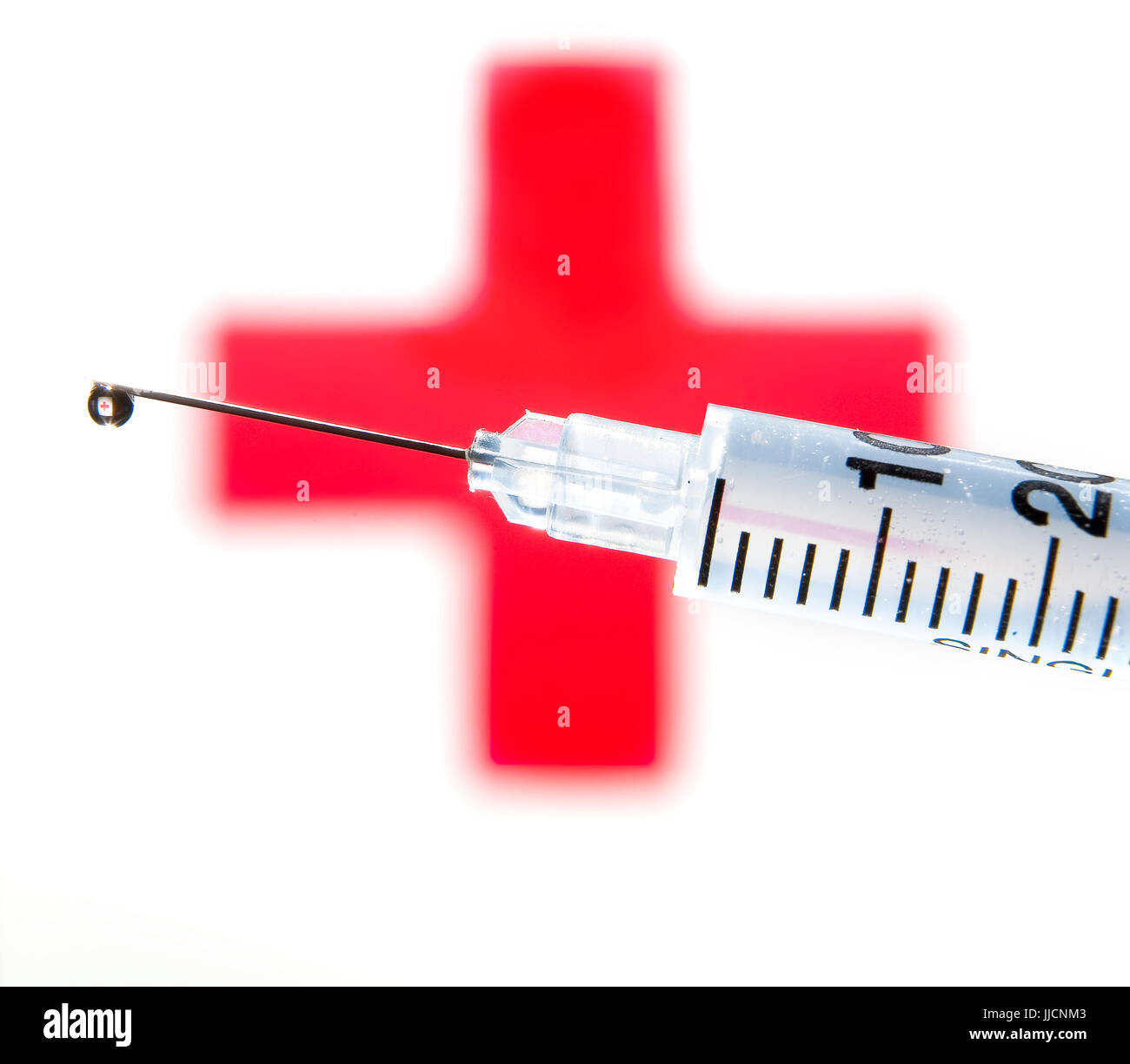 A drop of liquid on the tip of a needle of a medical syringe on the ...