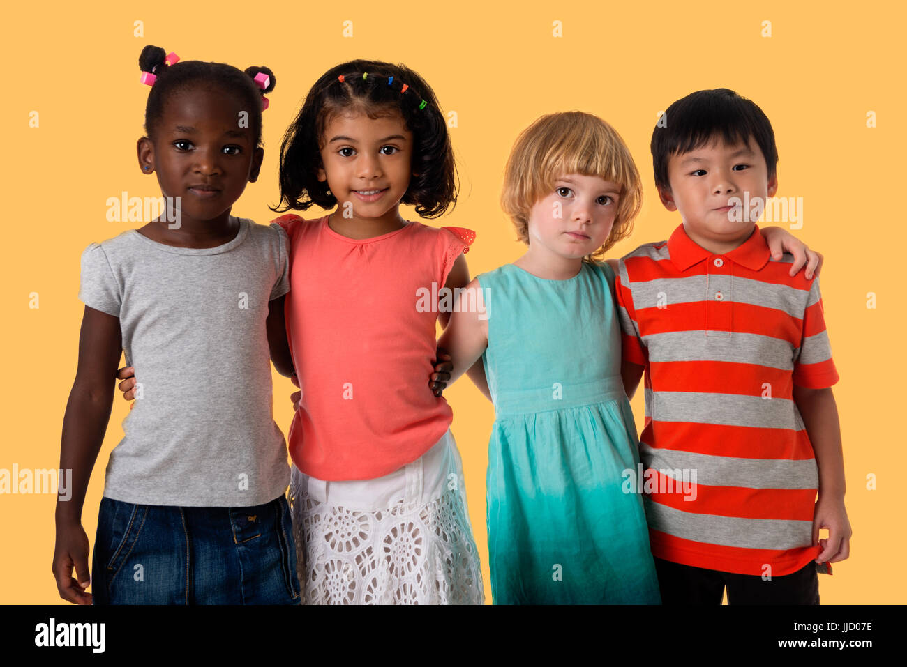 Group of multiracial happy kids portrait on yellow background. Studio ...