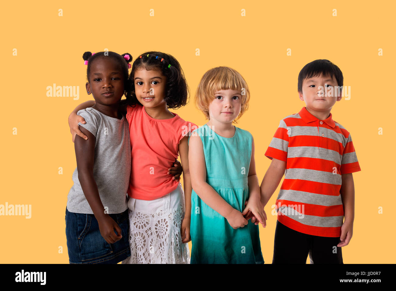 Group of multiracial kids portrait in studio on yellow background Stock ...