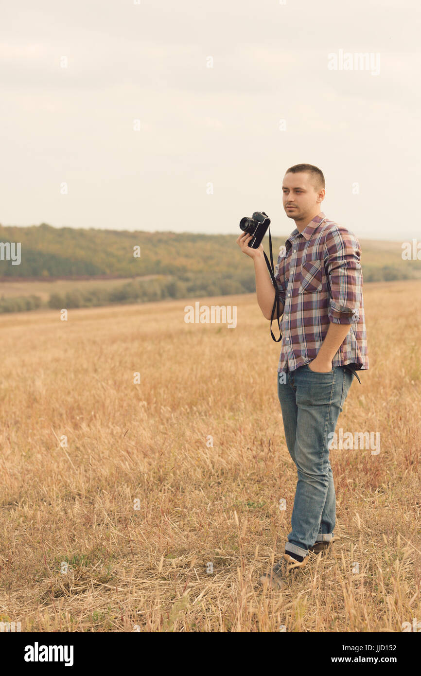 Portrait of attractive male photographer outdoors at sunset. Young man ...