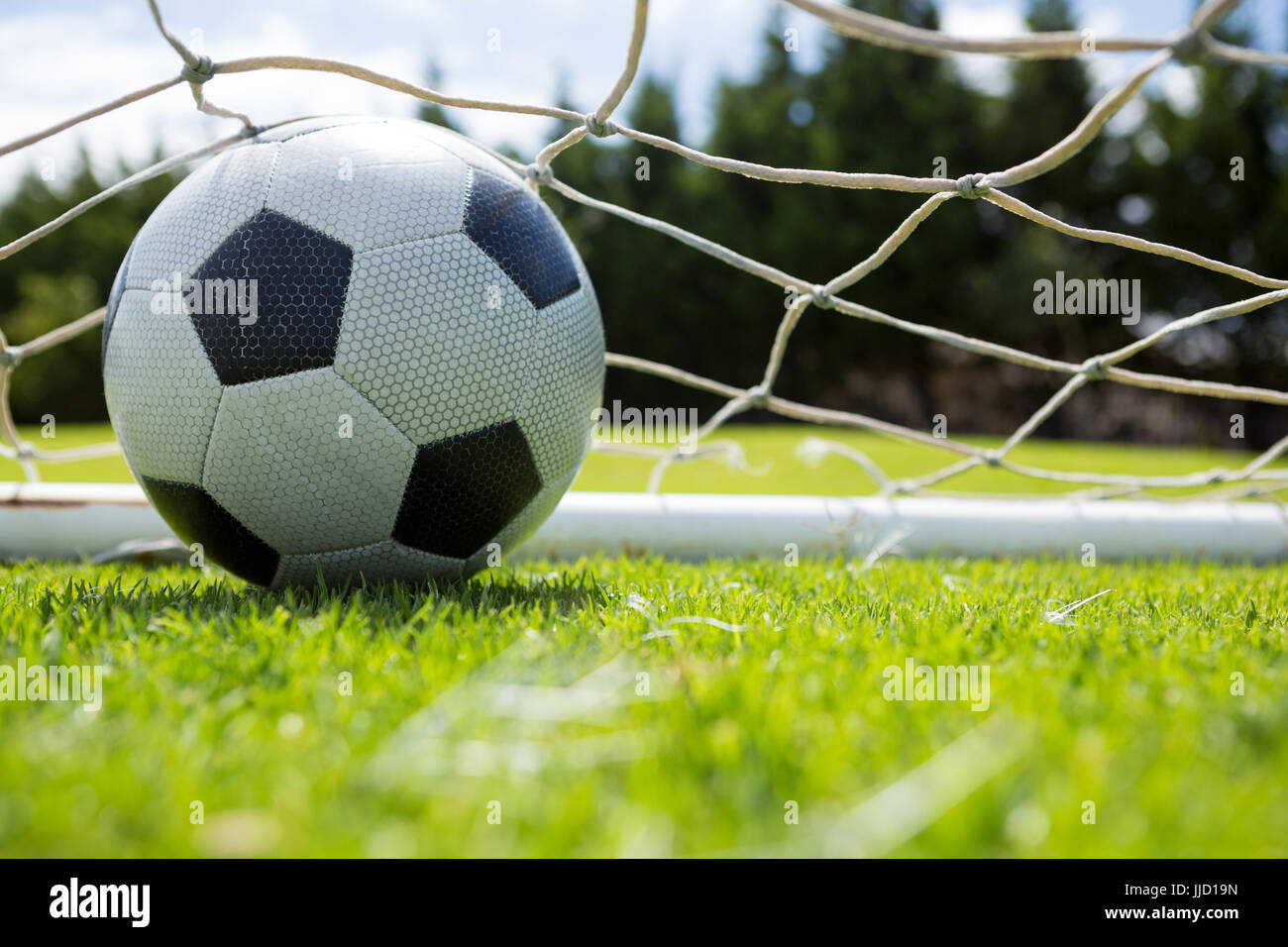 Close up of soccer ball in goal post at field Stock Photo - Alamy