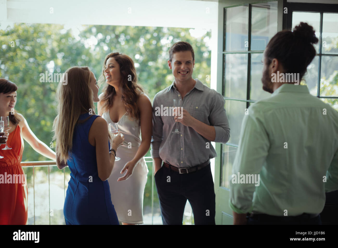 Group of friends interacting with each other while having cocktail ...