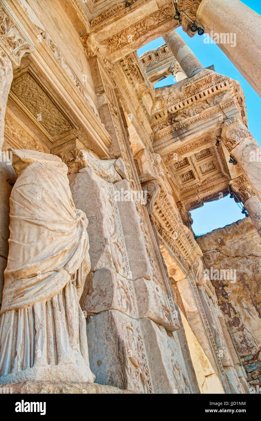 fragment of female statue in Celsus Library facade with columns at low ...