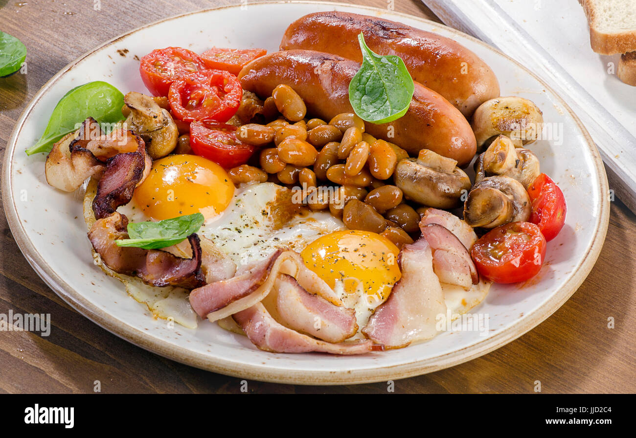 Full english breakfast with fried egg, beans, tomatoes, mushrooms ...