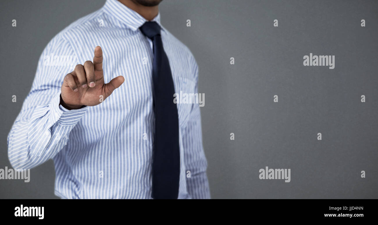 Mid section of businessman using invisible screen against grey ...