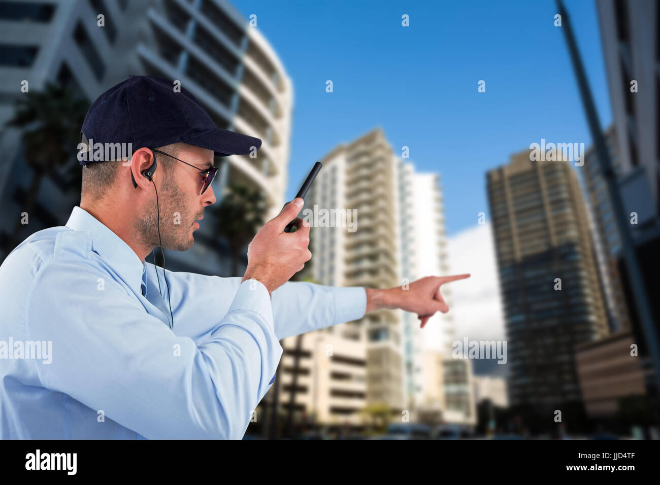 Security officer pointing away while talking on walkie talkie against ...