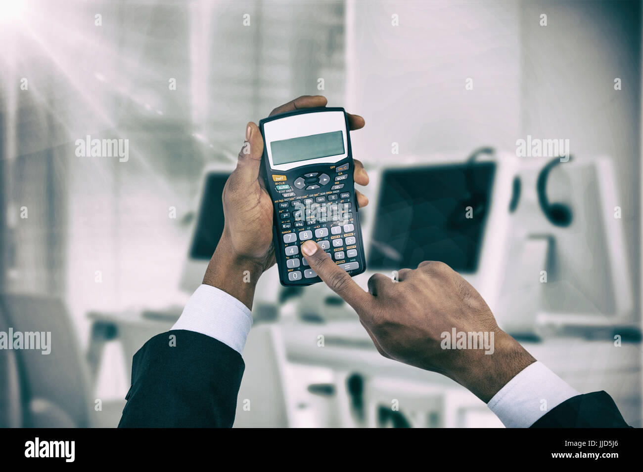 Cropped hands of businessman using calculator against computers and ...