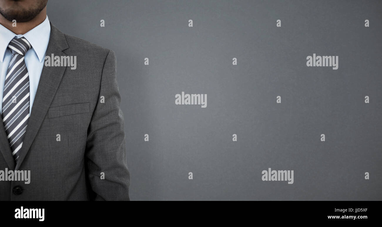 Businessman standing against white background against grey background ...