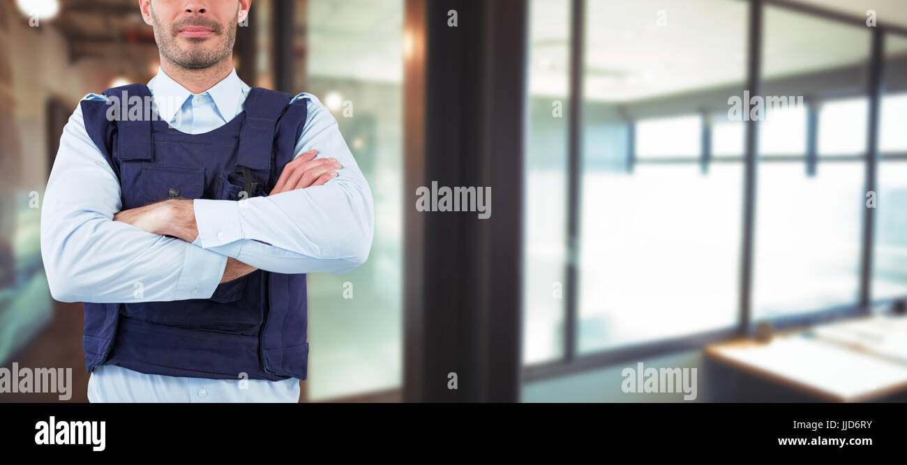 Confident security standing with arms crossed against view of office ...