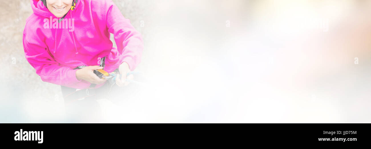 Portrait of woman abseiling down from rock face on mountain Stock Photo ...