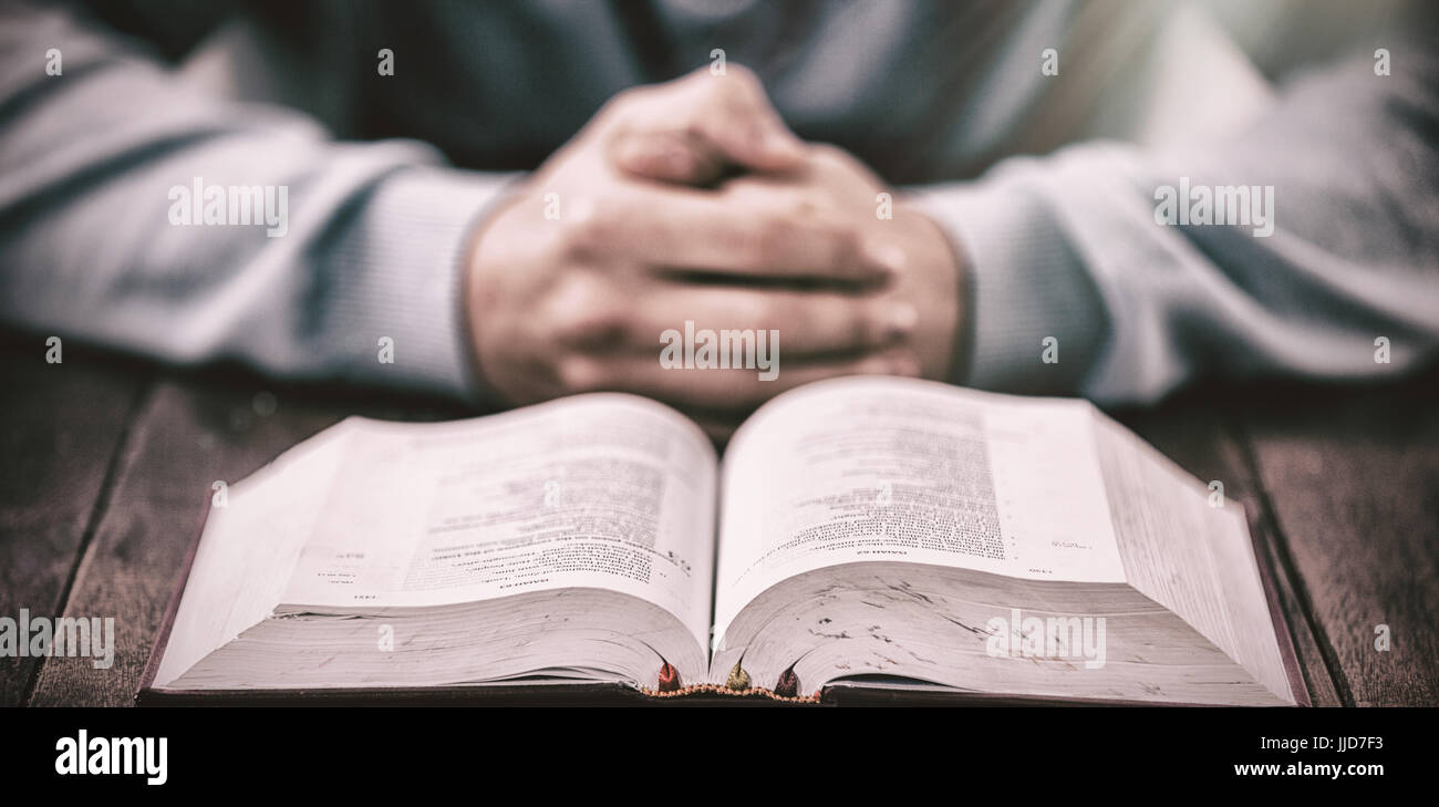 High angle view of man with bible praying at wooden table Stock Photo ...