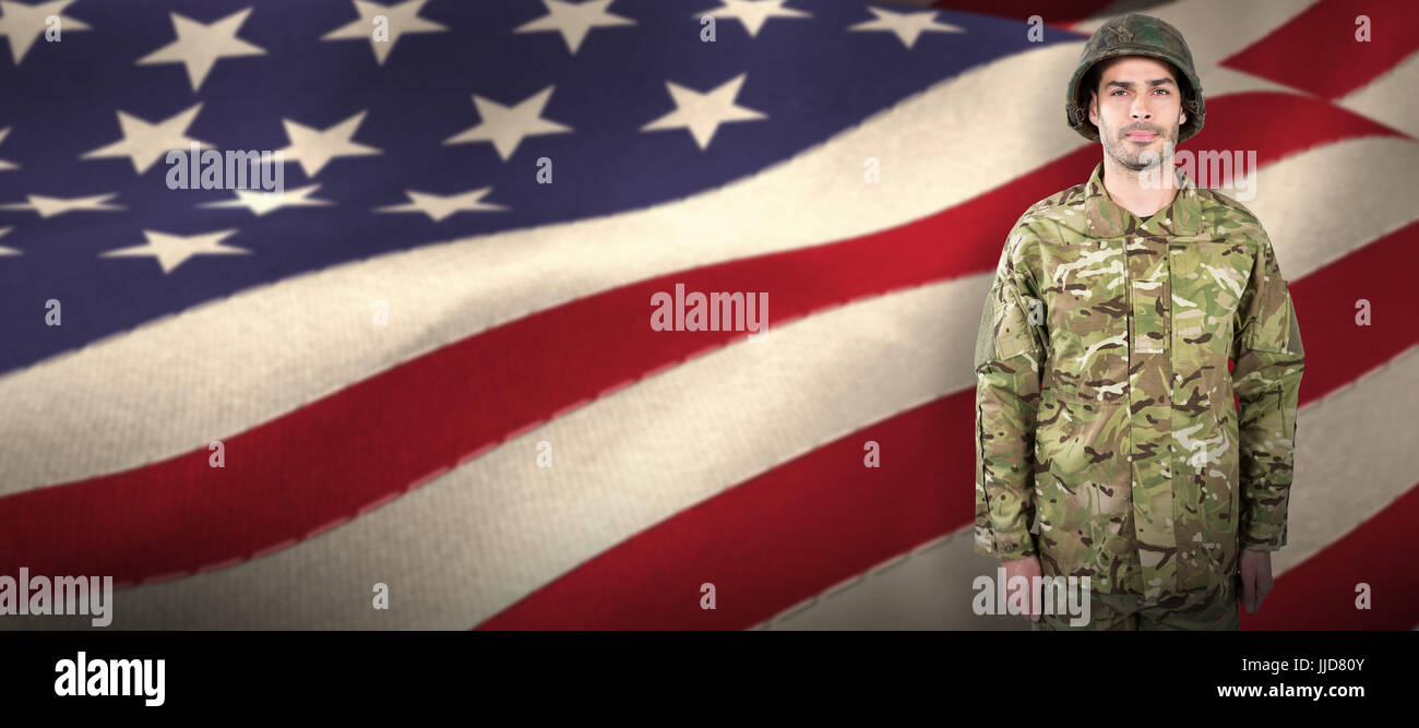Portrait of confident military soldier standing against waving flag of ...