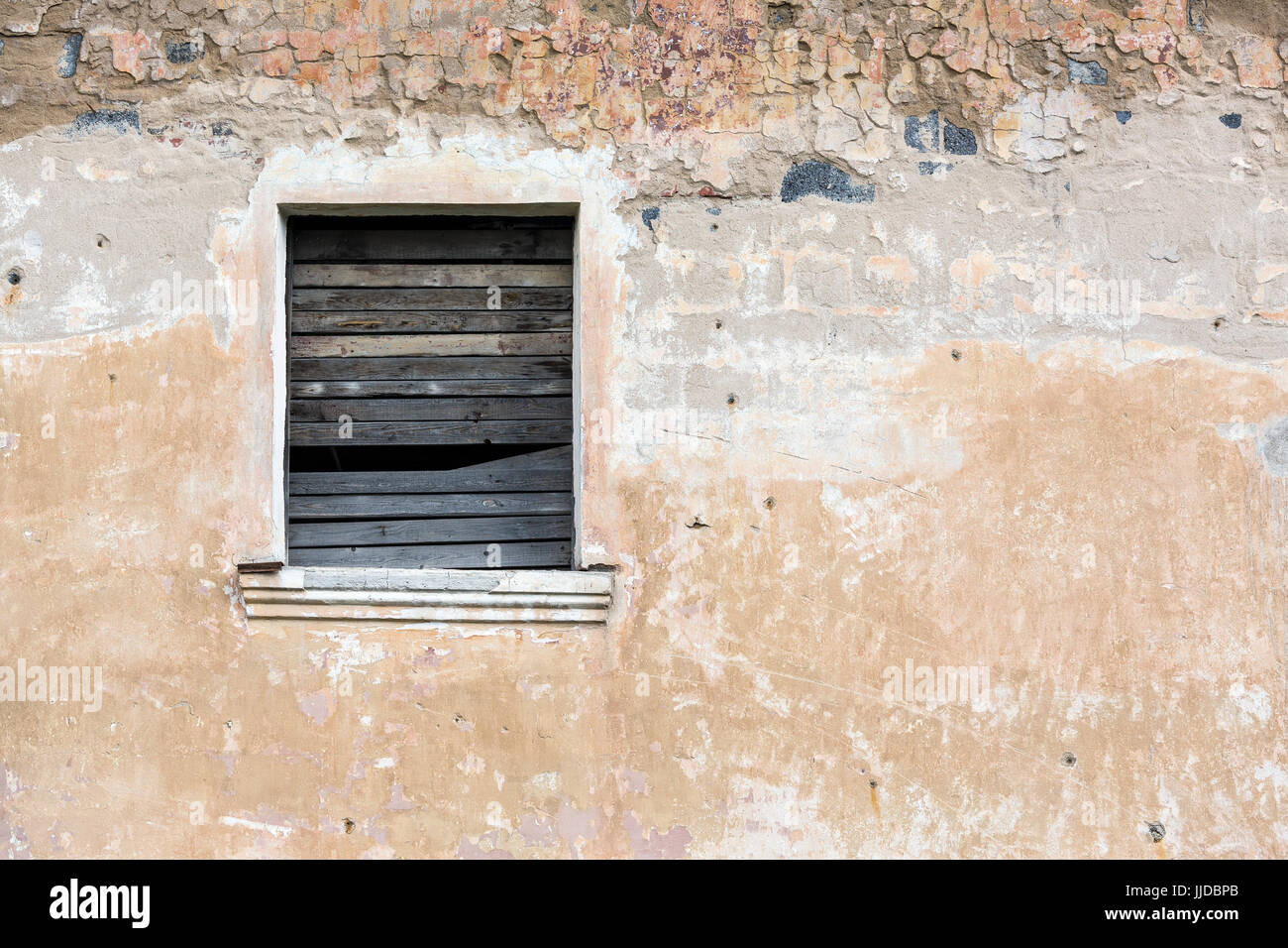 boarded up window on yellow plaster wall with peeling paint Stock Photo ...