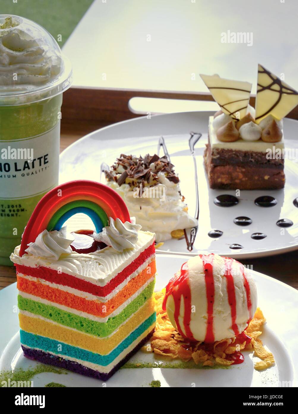 Piece of rectangular shape velvet rainbow cake with scoop of vanilla ...