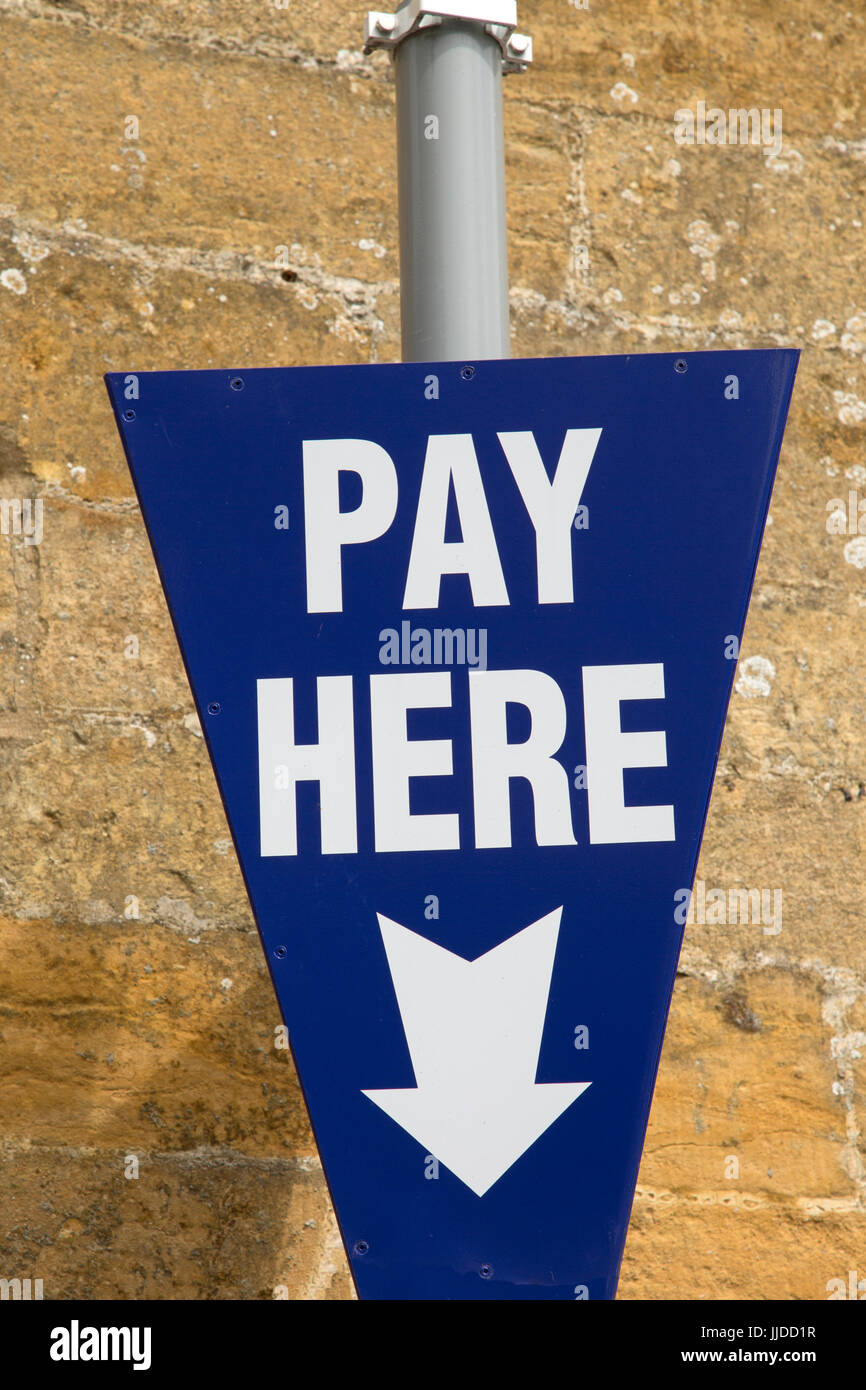 Pay Here Sign against Stone Wall Stock Photo - Alamy