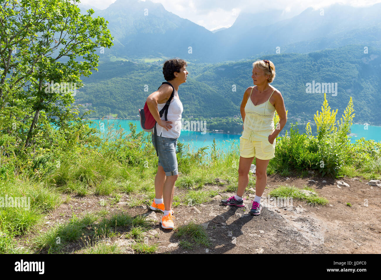 Two hiker women talking near of Lake of Annecy Stock Photo - Alamy