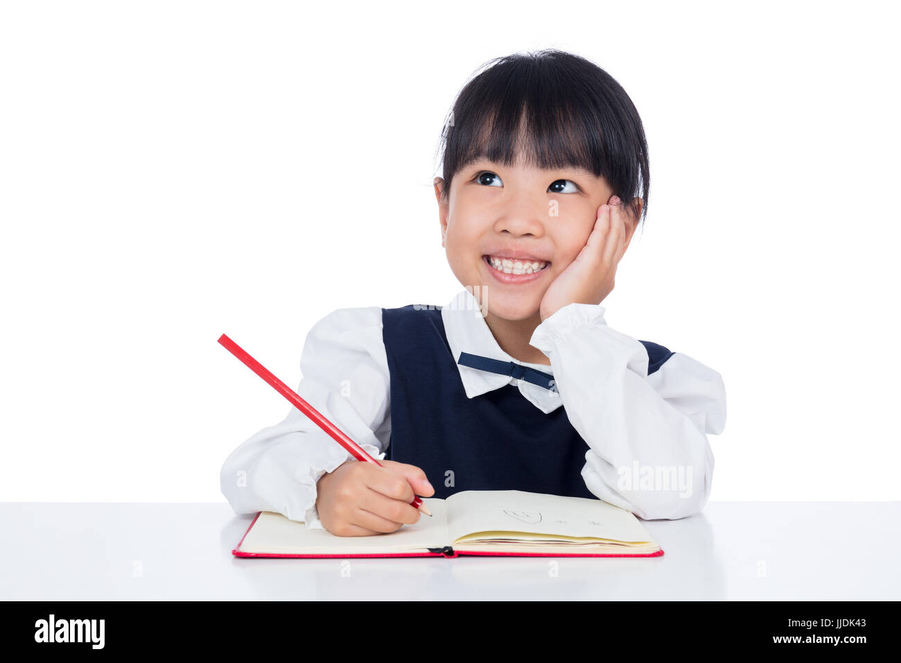 Asian Little Chinese girl writing homework in isolated white background ...