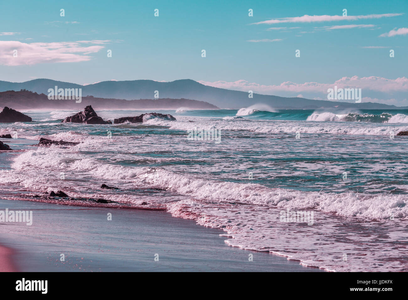 Beautiful landscape of ocean waves, coastal rocks and hills with copy ...