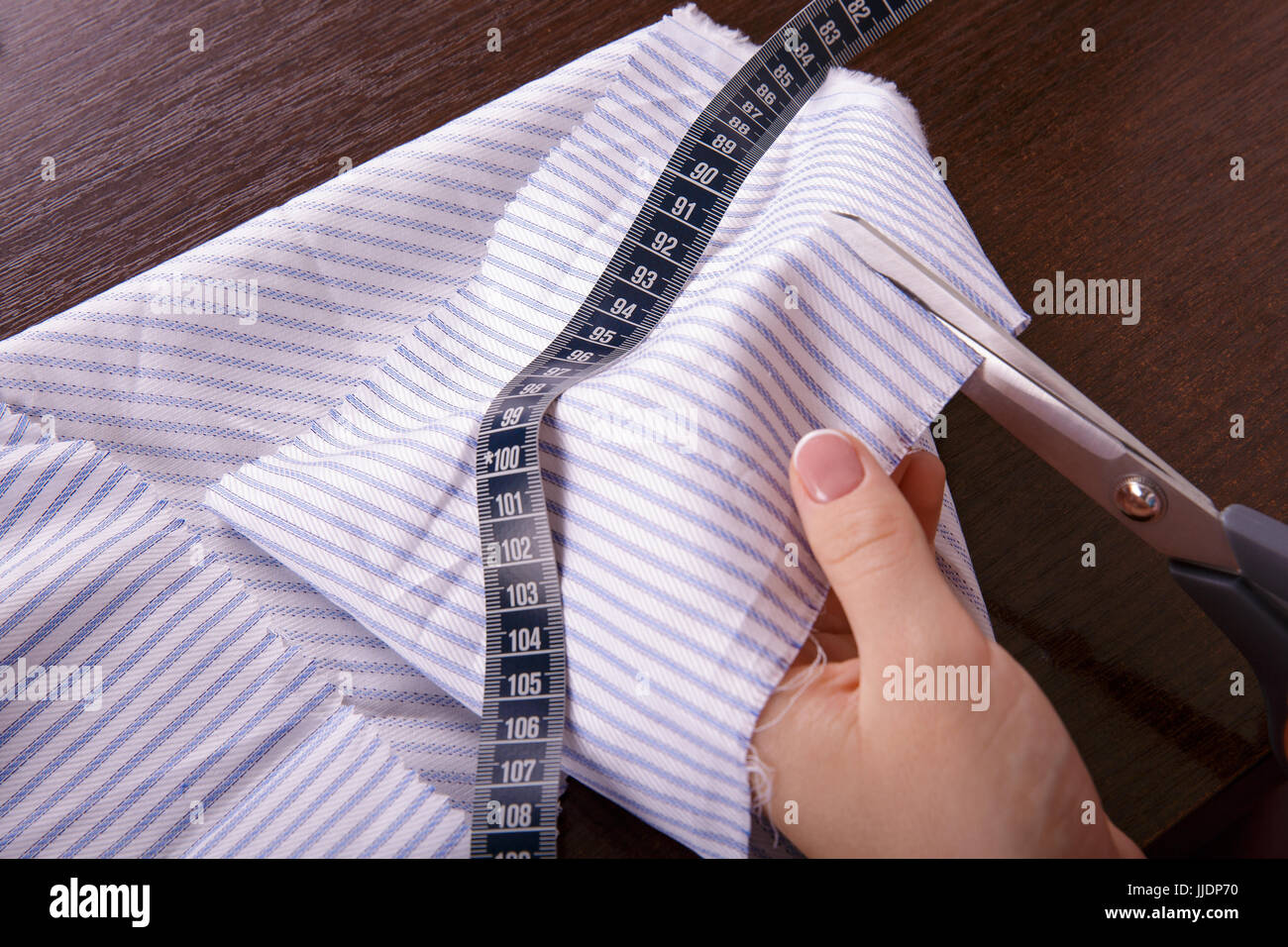 Process of sewing. Fabric cutting Centimeter Hands Stock Photo - Alamy