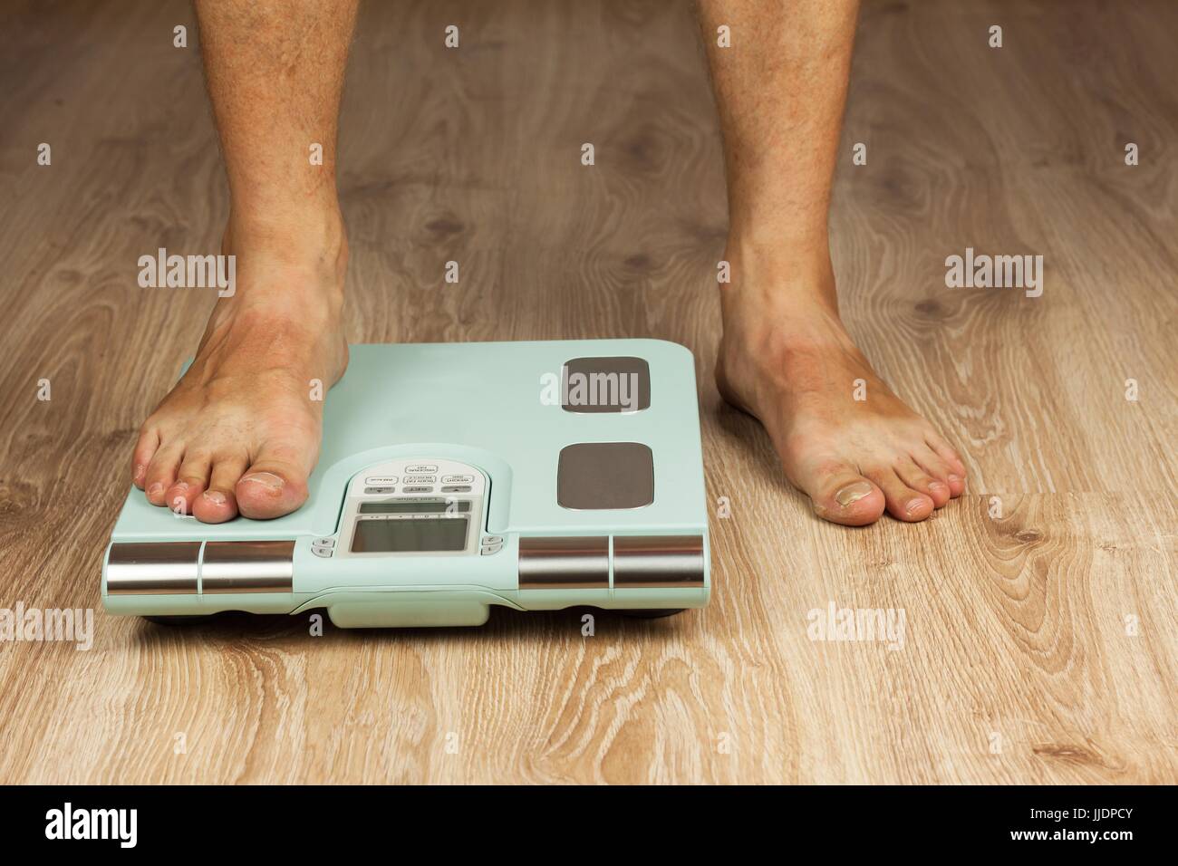 The old man is standing on a modern scale. Measuring the fat content of ...