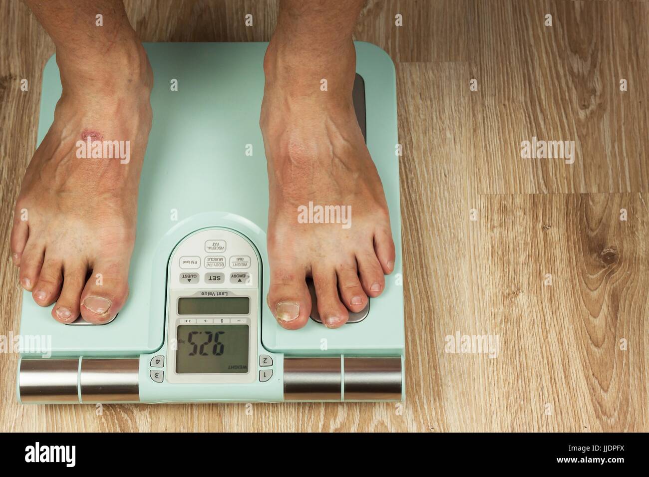 The old man is standing on a modern scale. Measuring the fat content of ...