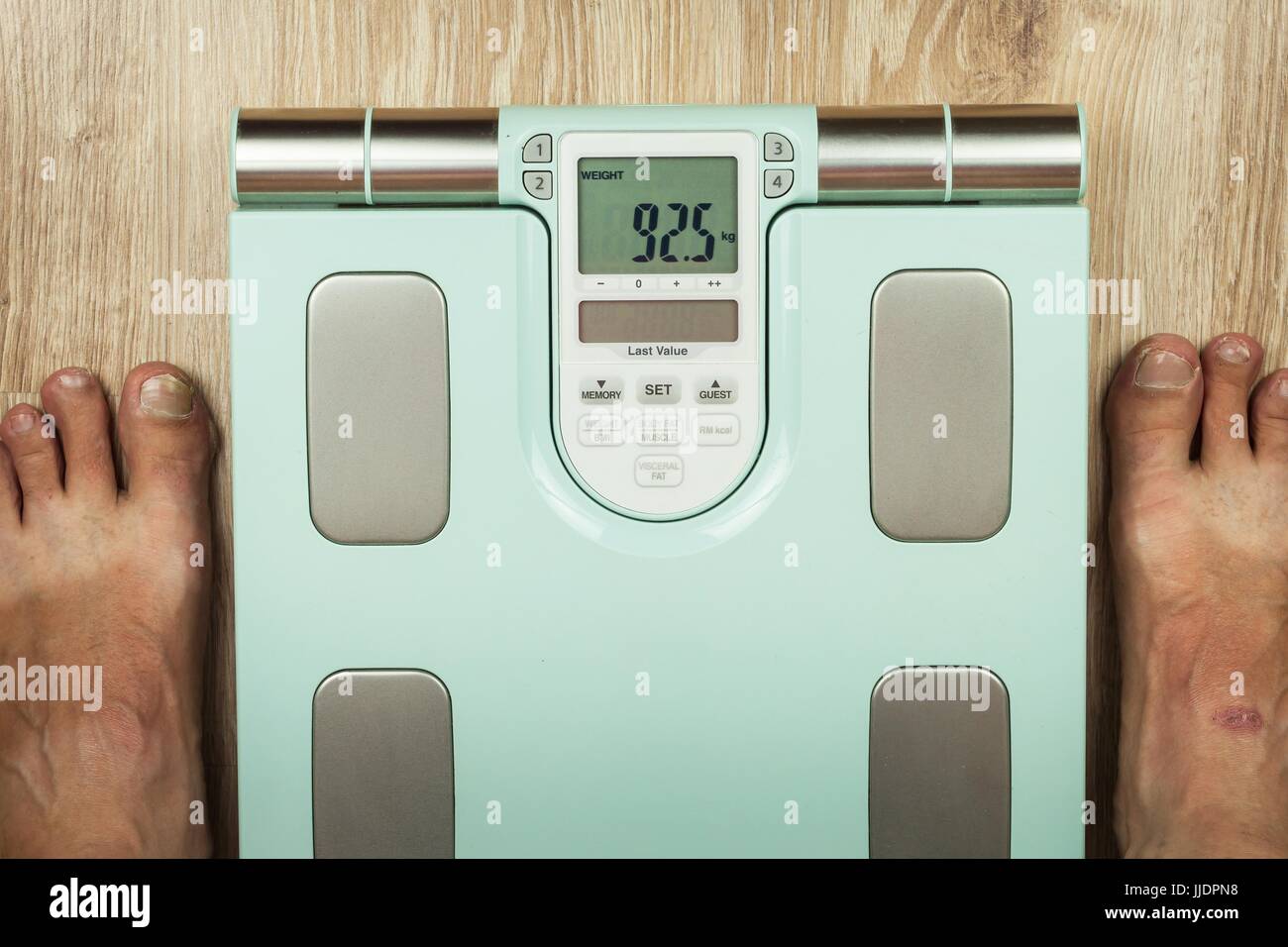 The old man is standing on a modern scale. Measuring the fat content of ...