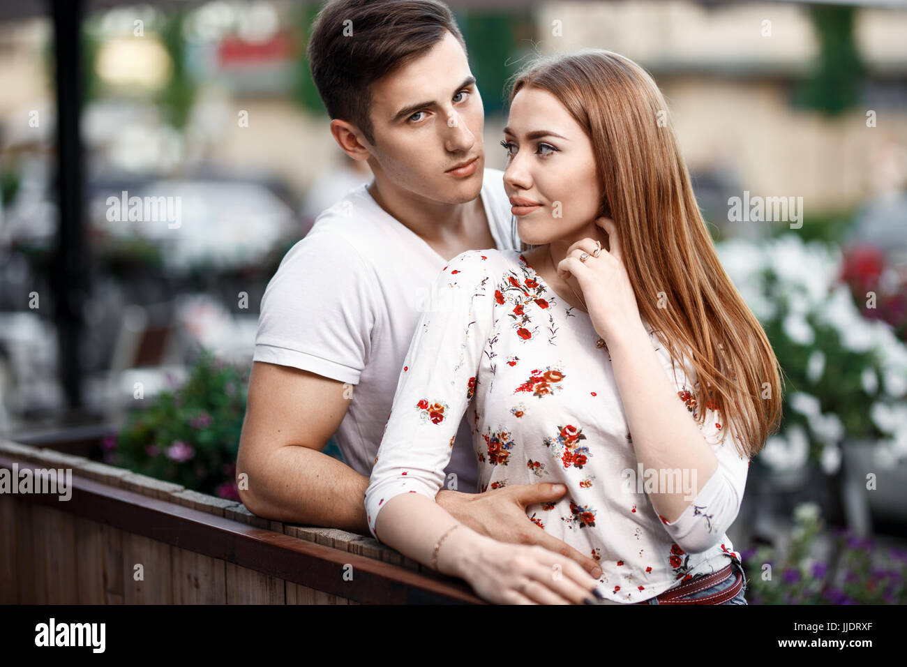 Portrait of young modern couple in love, posing outdoors in city street ...