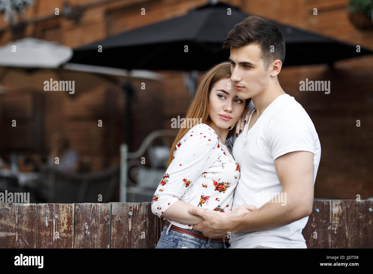 Portrait of young modern couple in love, posing outdoors in city street ...
