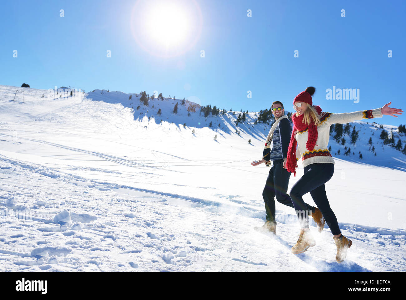 Cheerful young couple having fun in winter park Stock Photo - Alamy