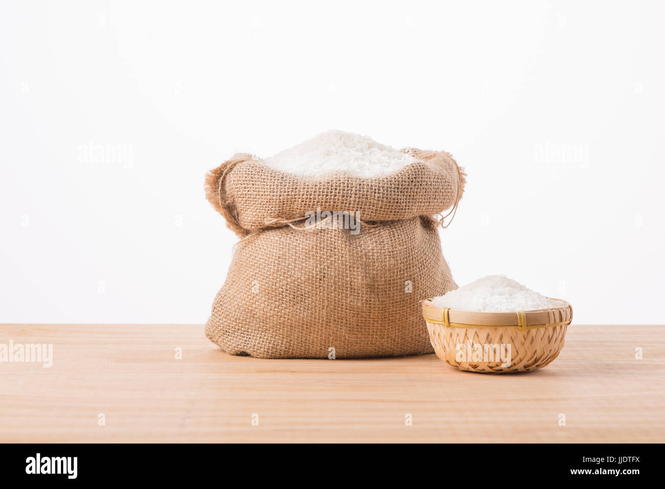 Jasmine white rice in sack isolated on white background Stock Photo - Alamy