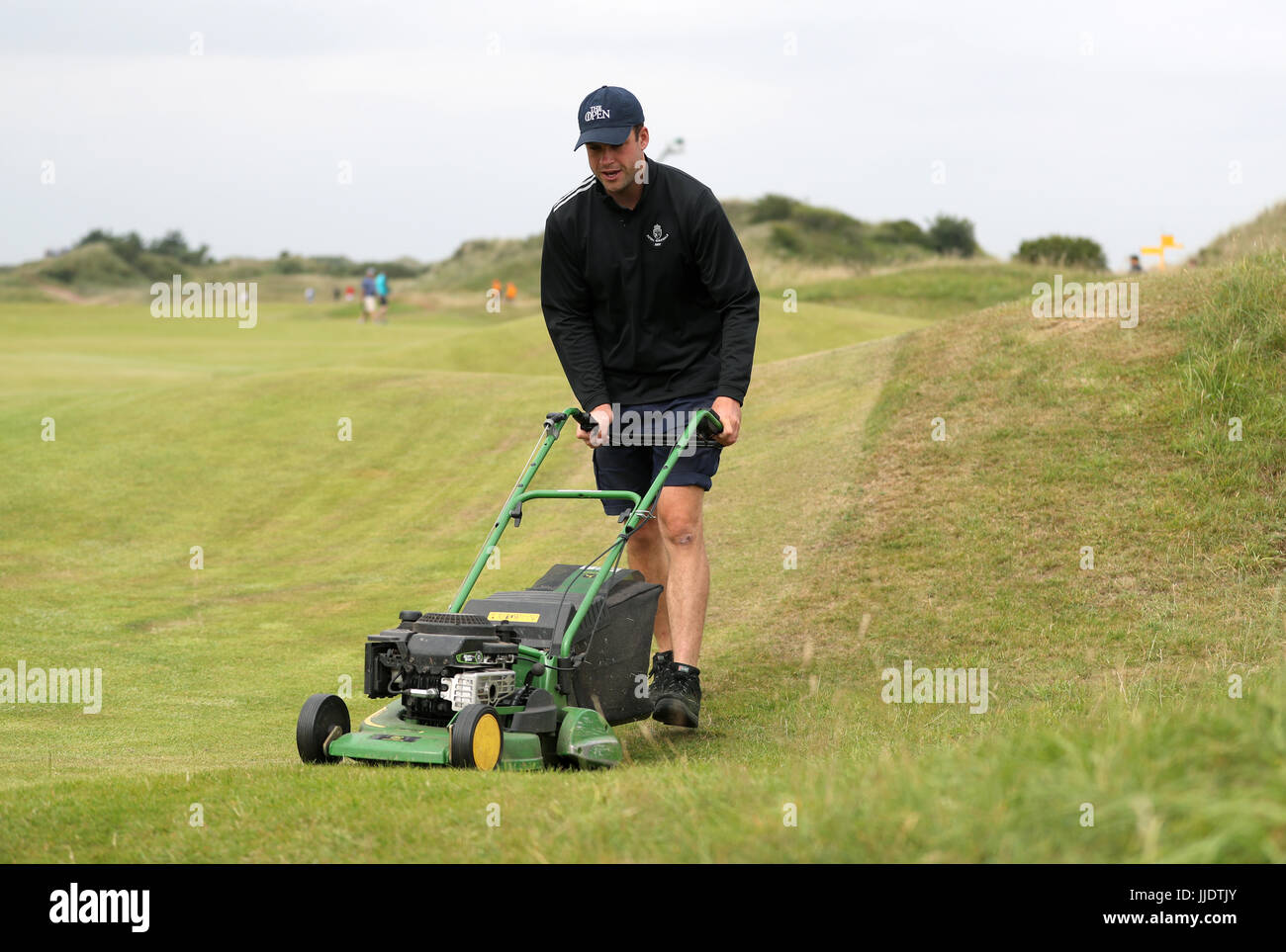 A groundsman cuts the grass on the 3rd green during practice day four ...