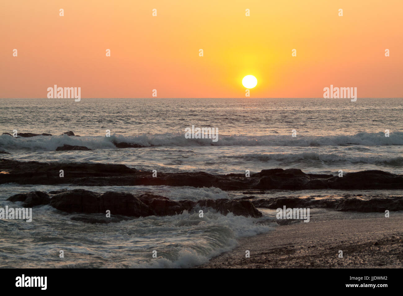 Sunset beach with reef Stock Photo - Alamy