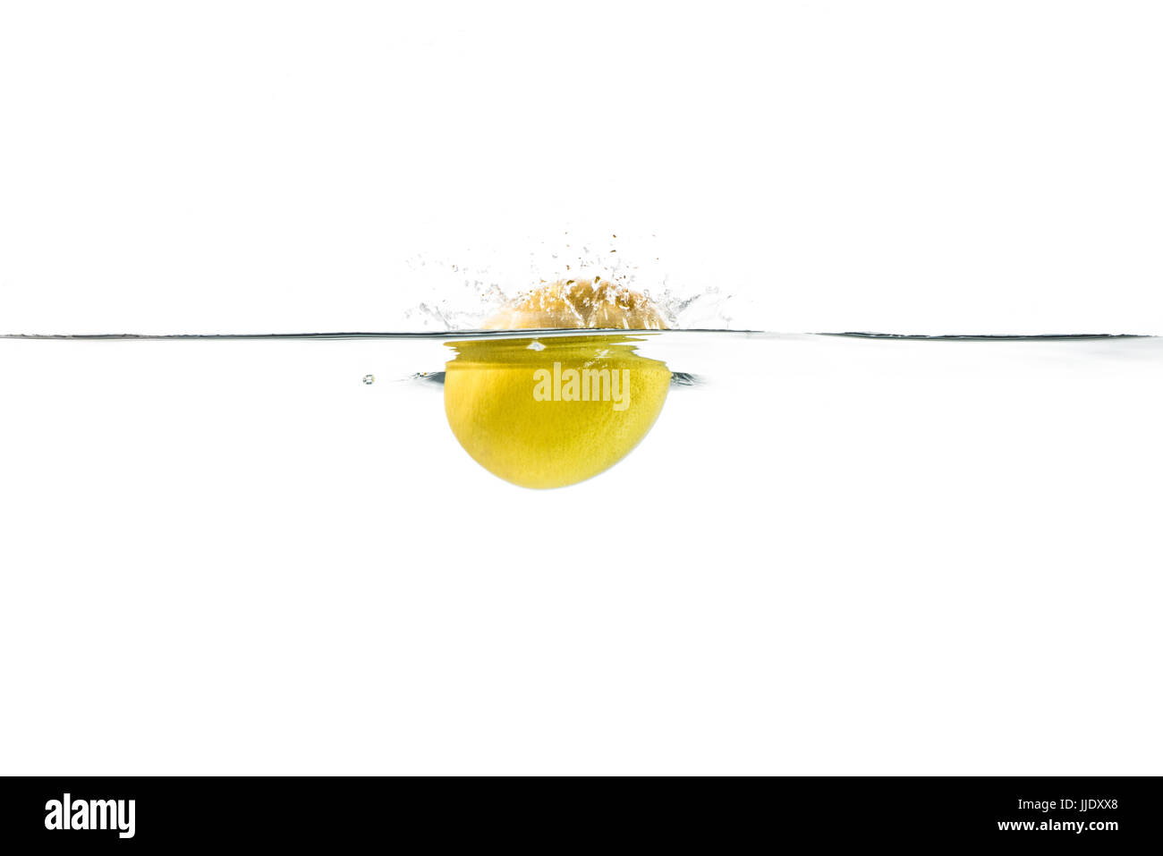 Fresh lemon dropped into the water with water splash on a white ...