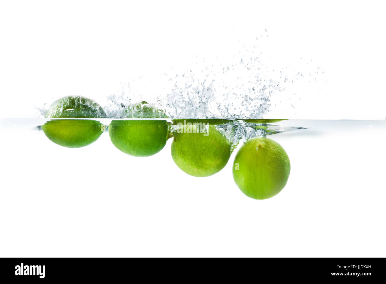 Fresh lime dropped into the water with water splash on a white ...