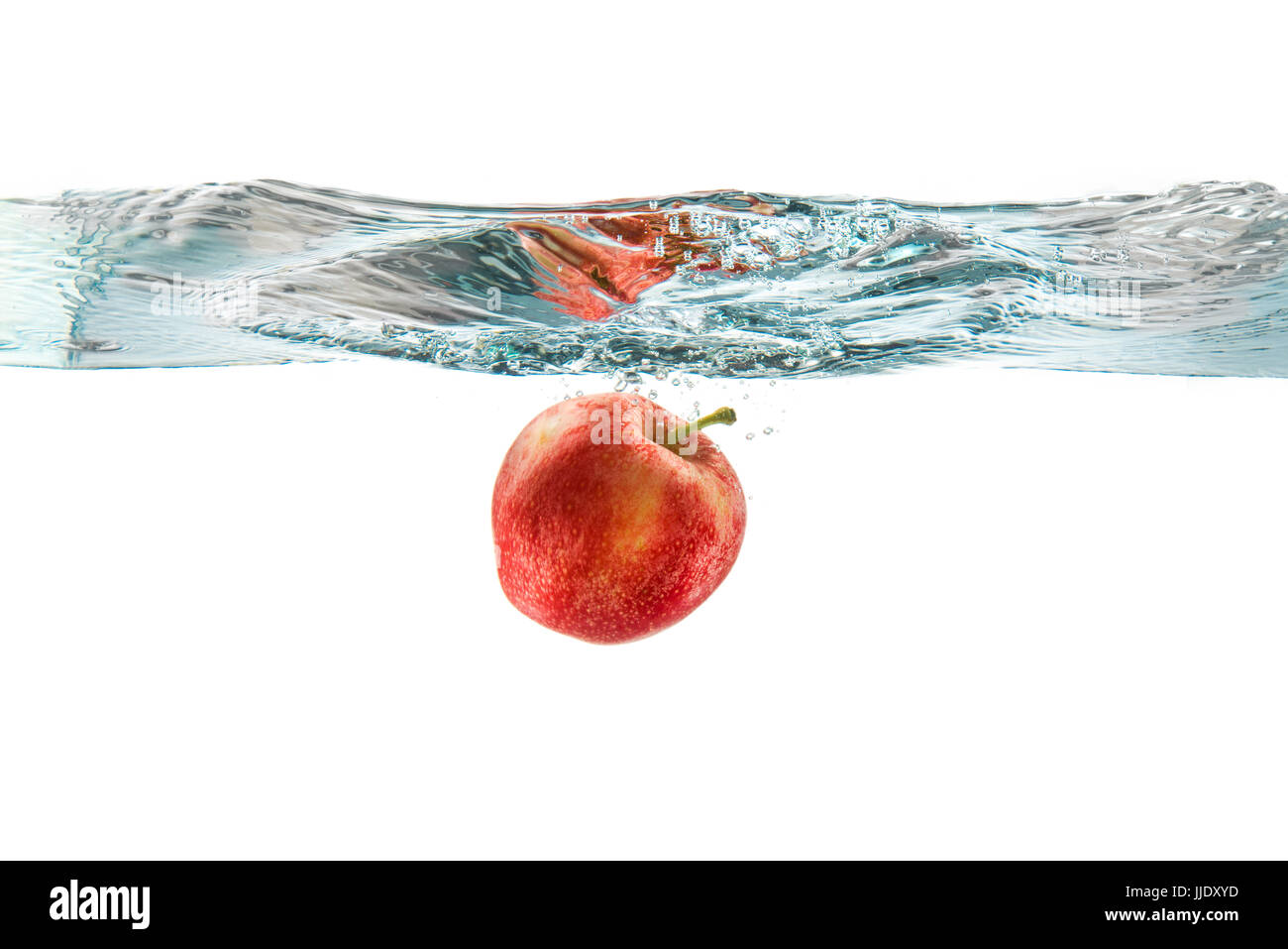 Red apple dropped into the water with water splash on a white ...