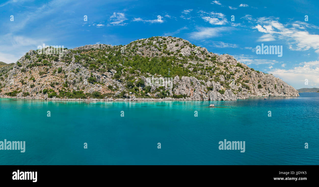 panoramic view of turquoise lagoon and rocky island against blue sky on ...